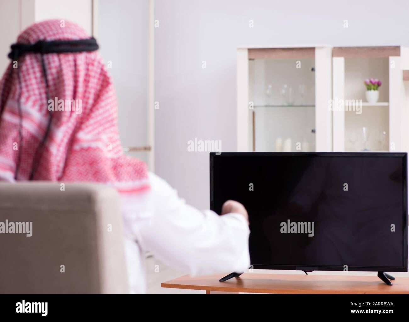 The arab man watching tv at home Stock Photo - Alamy