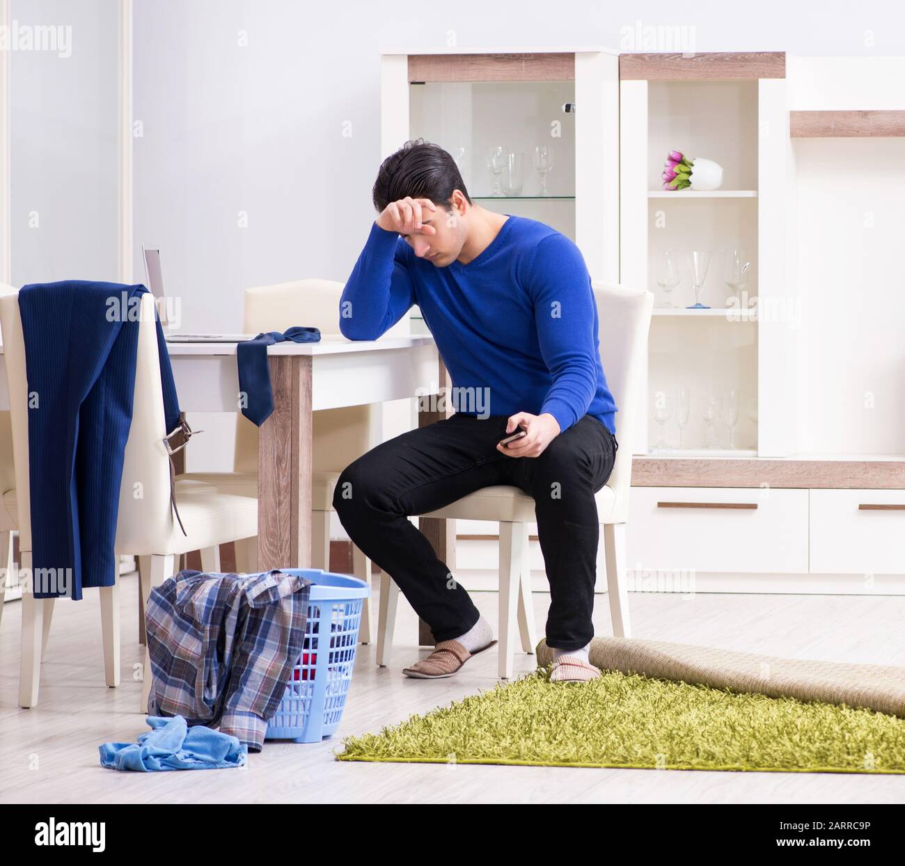 The young man collecting dirty clothing for laundry Stock Photo - Alamy