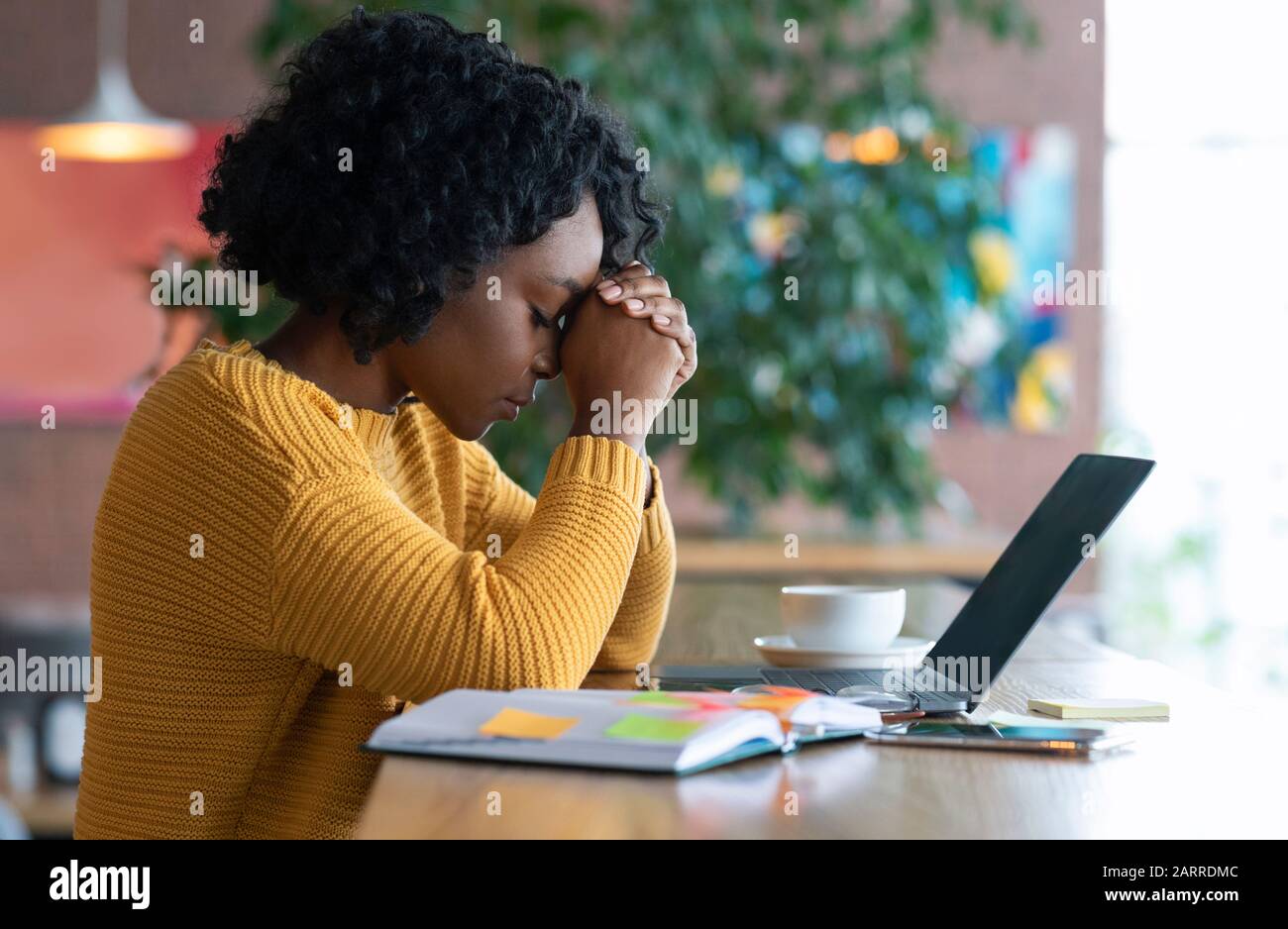 Exhausted african girl sitting in cafe, looking for job online Stock ...