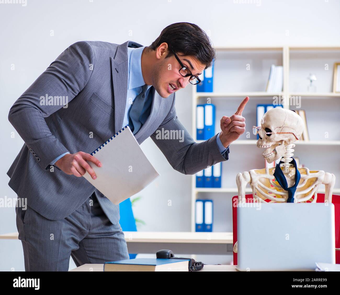 The angry boss yelling at his skeleton employee Stock Photo - Alamy