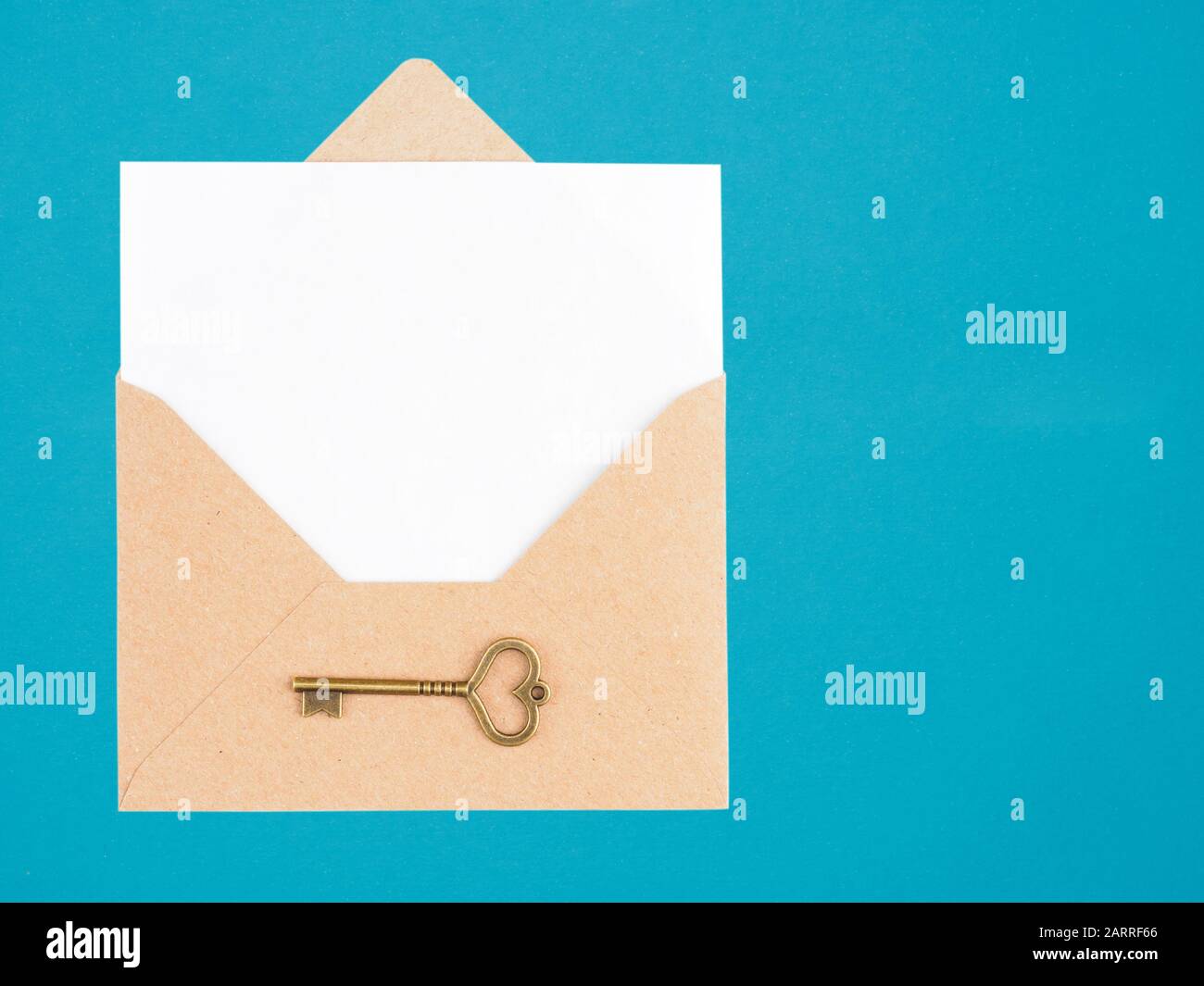 Kraft envelope with a white sheet and an antique key on a blue ...