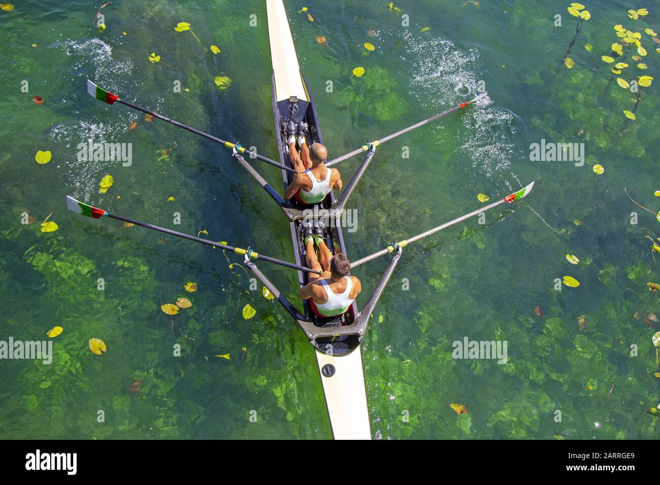 Two young athletes rowing team on turquoise green lake Stock Photo - Alamy
