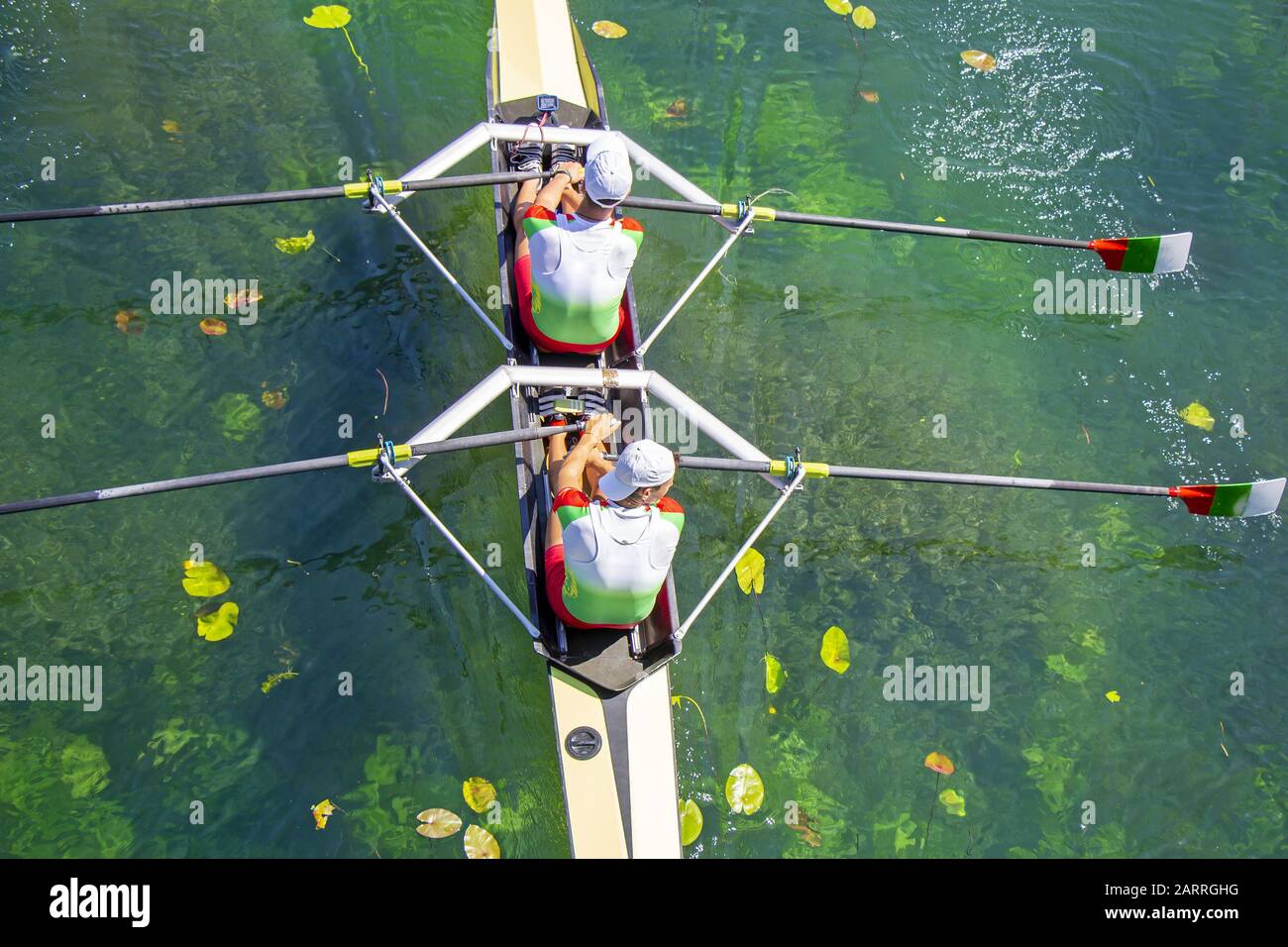 Two young athletes rowing team on turquoise green lake Stock Photo - Alamy