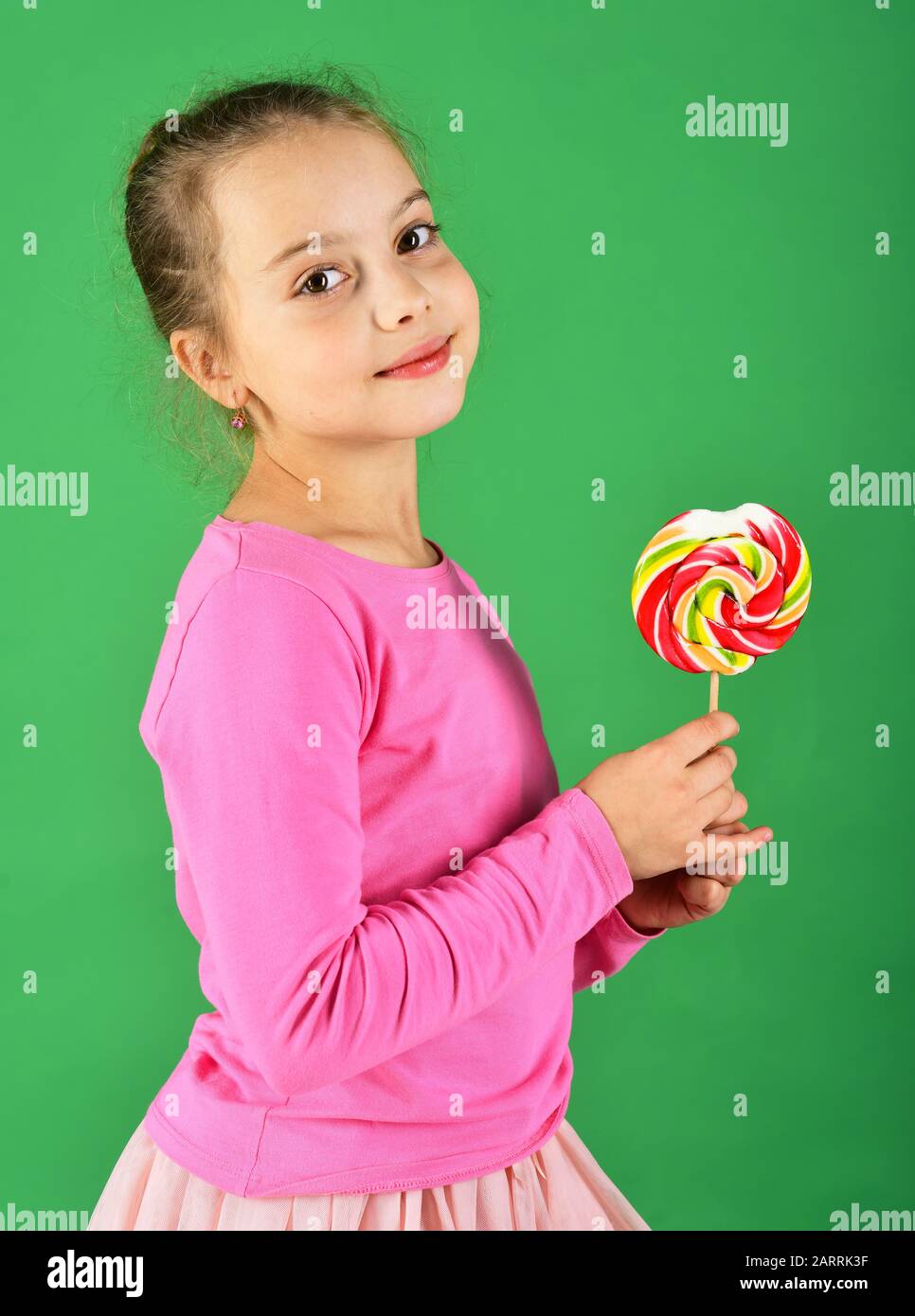 Lady holds round shaped lollipop. Child with happy face poses with ...