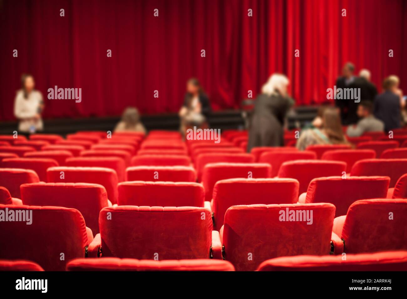 red theater seats and audience coming Stock Photo - Alamy