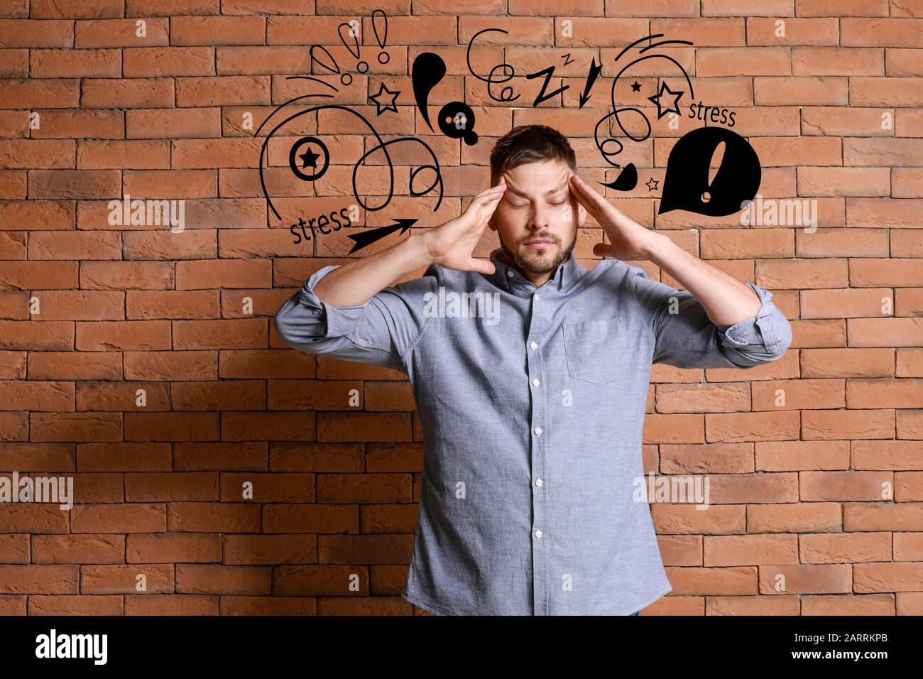 Stressed man against brick wall Stock Photo - Alamy