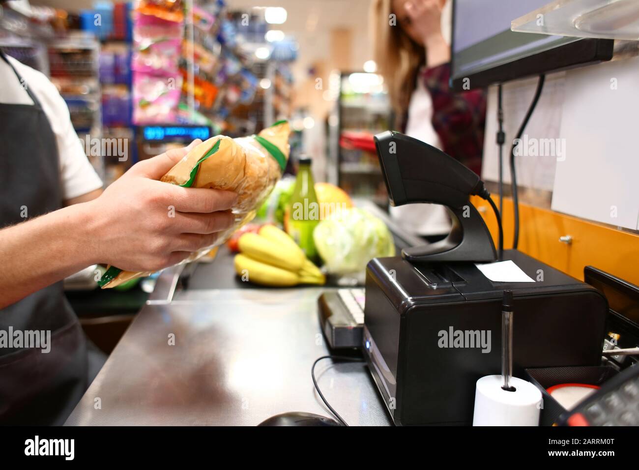 Male cashier checking out goods in supermarket Stock Photo - Alamy
