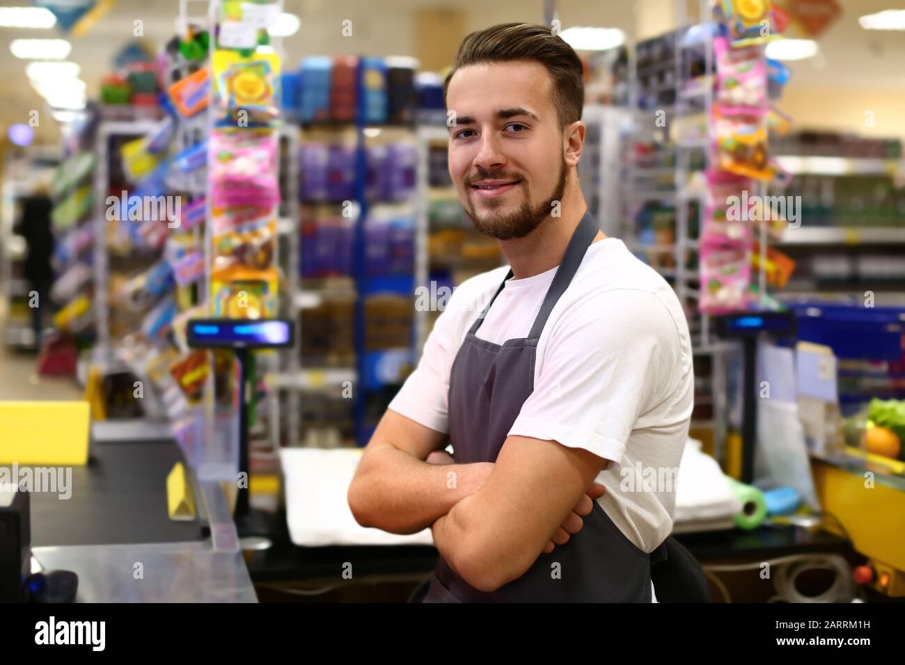 Portrait of male cashier in supermarket Stock Photo - Alamy