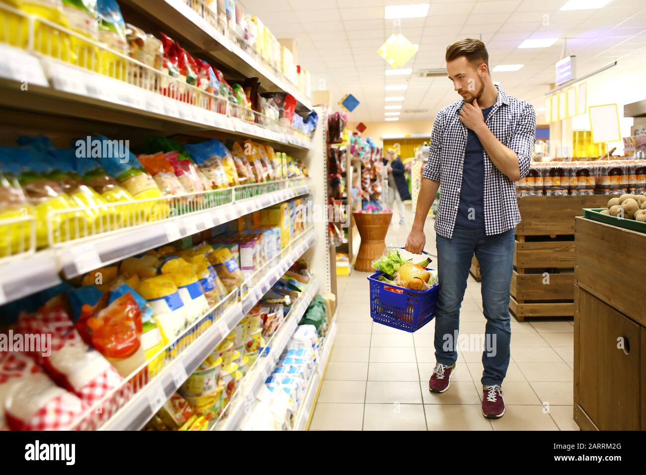Young man choosing food in supermarket Stock Photo - Alamy