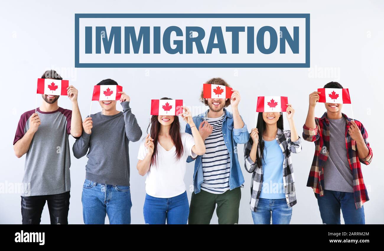Group of students with Canadian flags and word IMMIGRATION on light ...