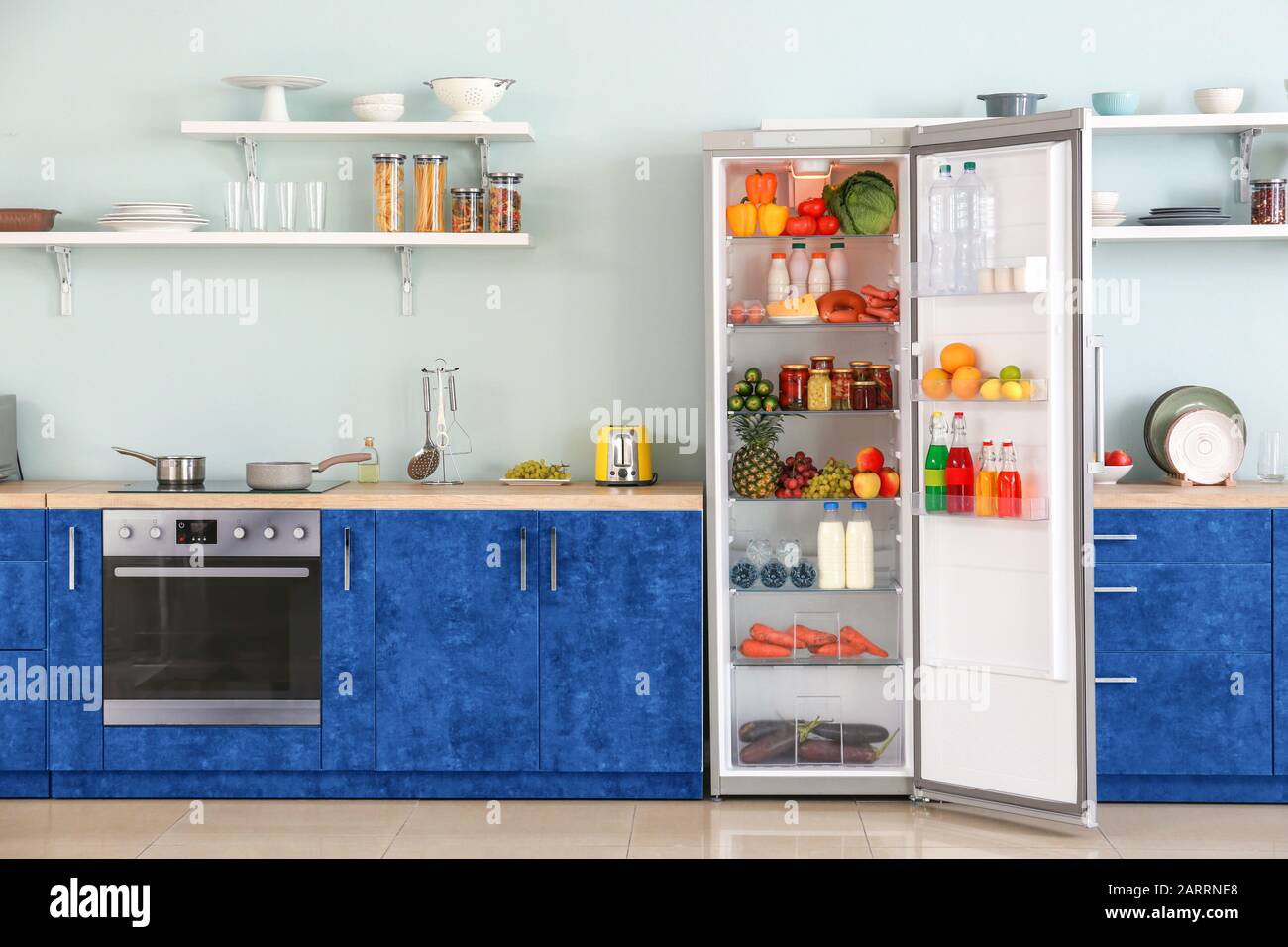 Open big fridge with products in interior of kitchen Stock Photo - Alamy