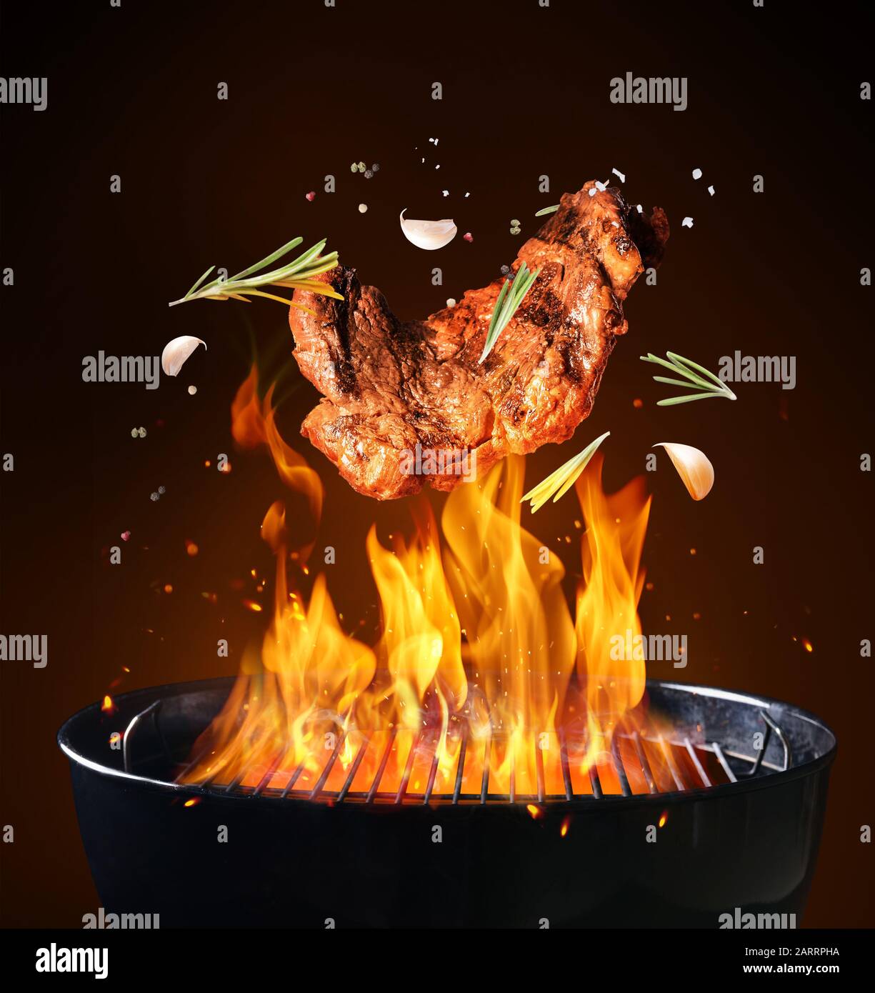 Falling tasty meat with spices on barbecue grill with flame against ...