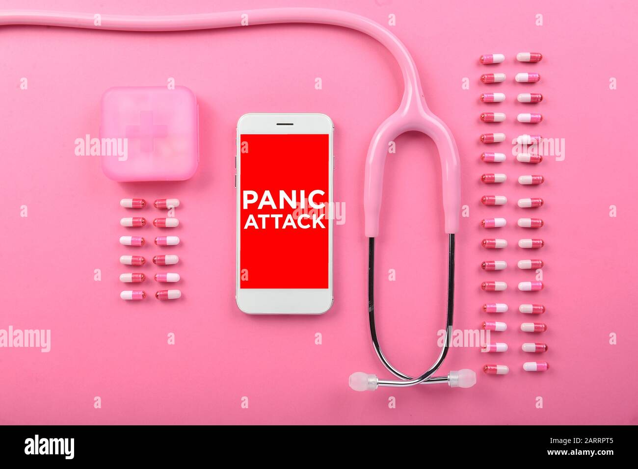 Mobile phone with text PANIC ATTACK on screen, stethoscope and pills on ...