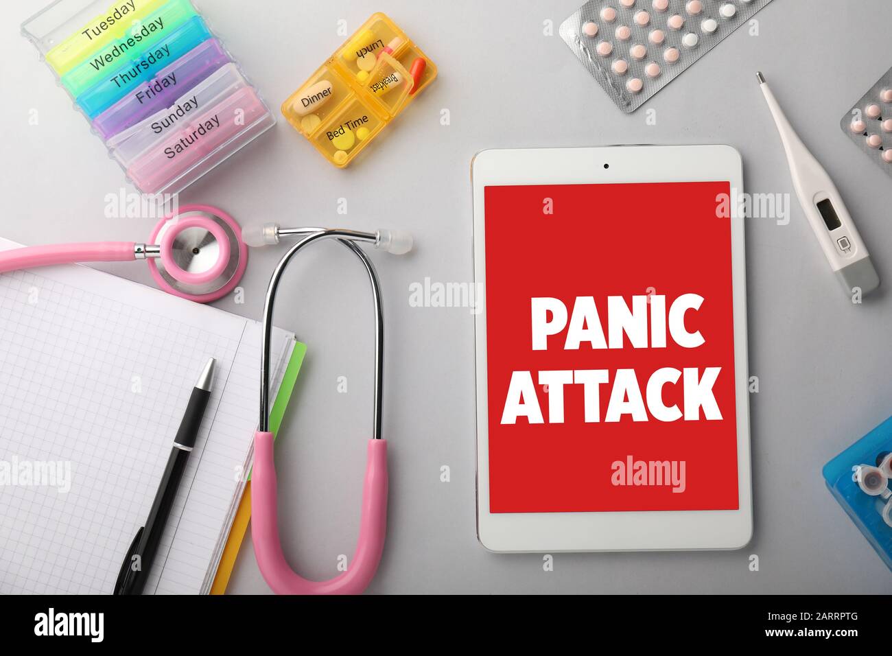 Tablet computer with text PANIC ATTACK, stethoscope and medicines on ...
