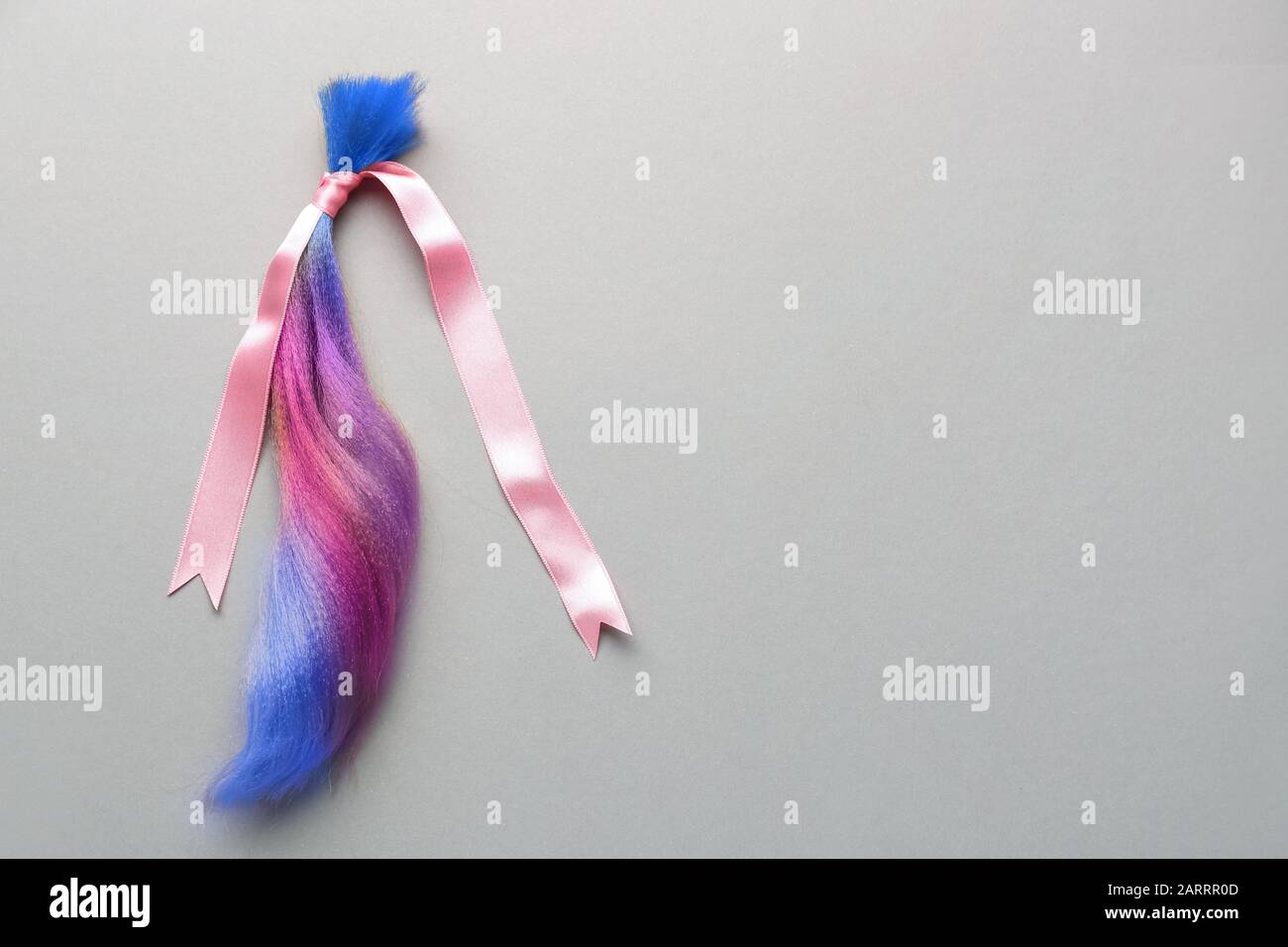 Colorful dyed hair strand and ribbon on grey background Stock Photo - Alamy