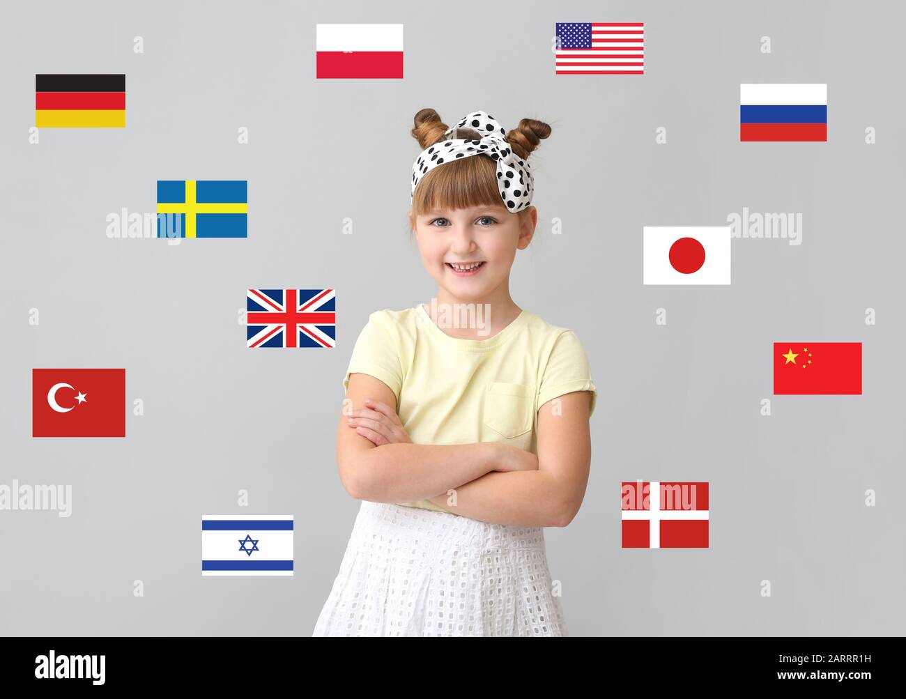 Little girl and flags of different countries on light background ...