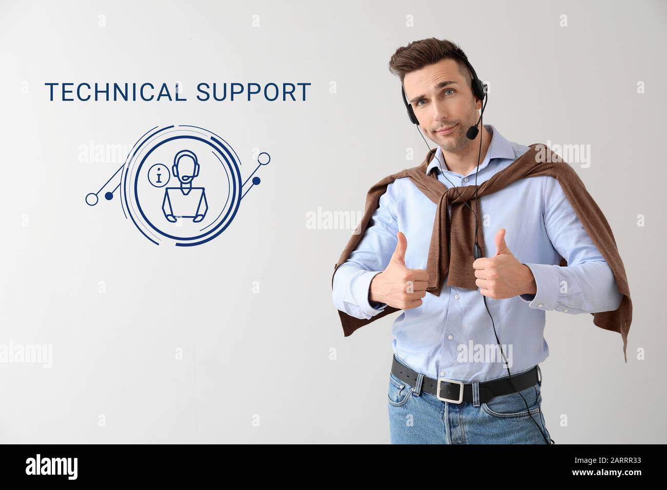 Male technical support agent showing thumb-up gesture on light ...