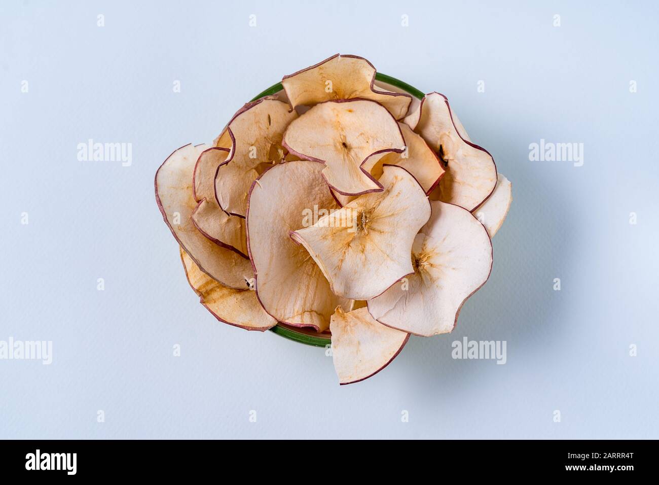 Flat lay Dried apple chips in a cup over light blue background Stock ...