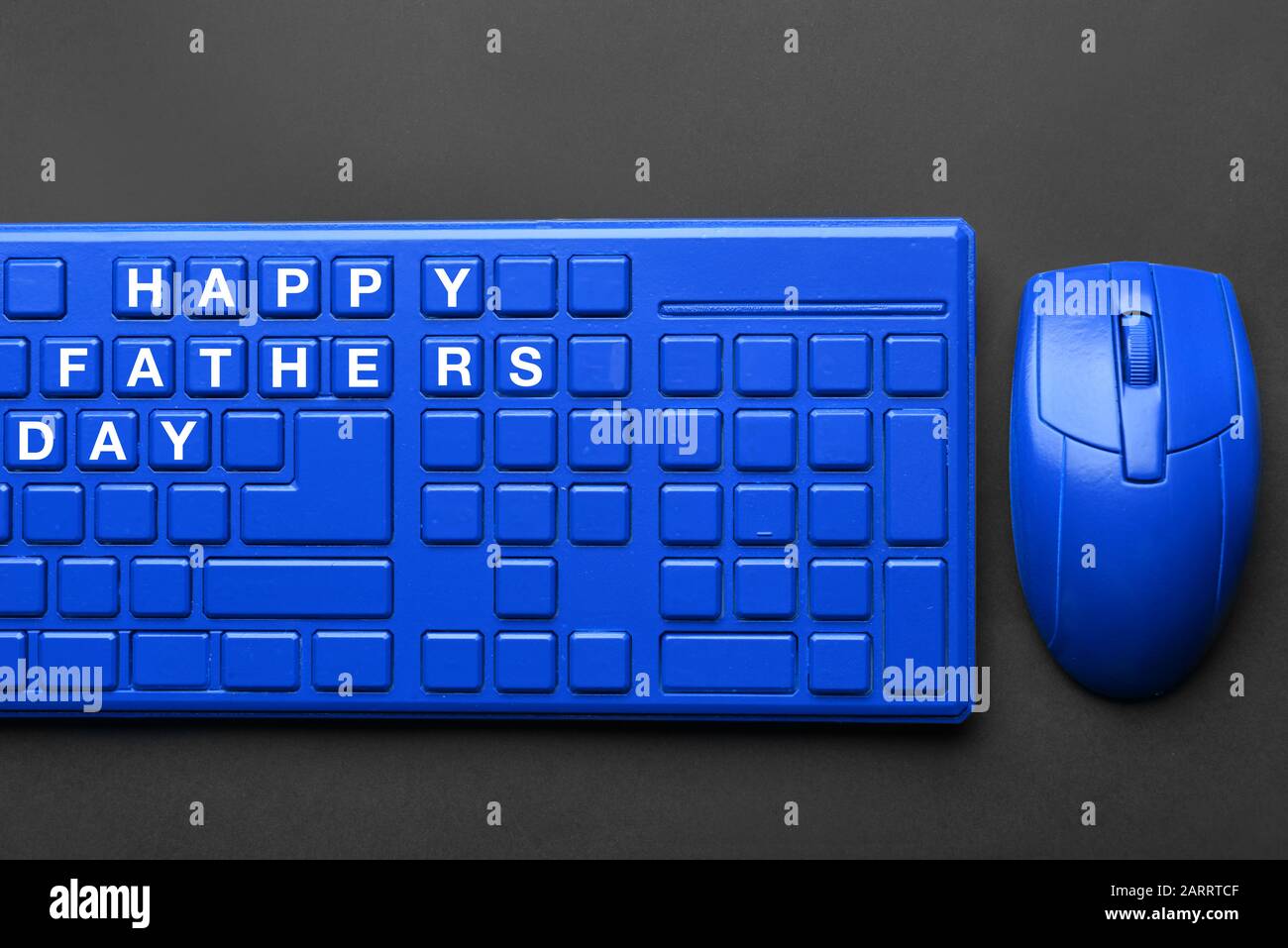 Blue computer mouse and keyboard with text HAPPY FATHER'S DAY on dark ...