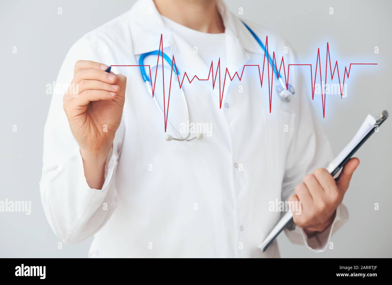 Male cardiologist drawing cardiogram against light background Stock ...
