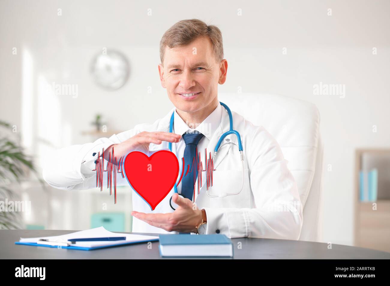 Male cardiologist with drawn heart and cardiogram in modern clinic ...