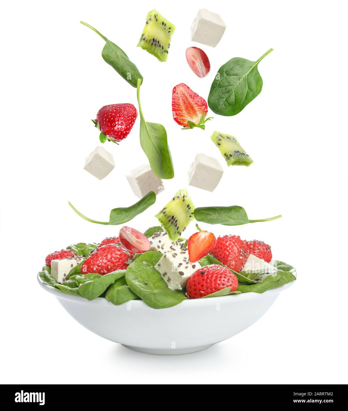 Bowl with fresh salad and falling ingredients on white background Stock ...