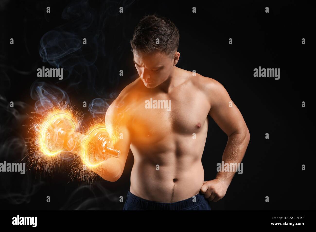 Handsome male bodybuilder with burning dumbbell on dark background ...