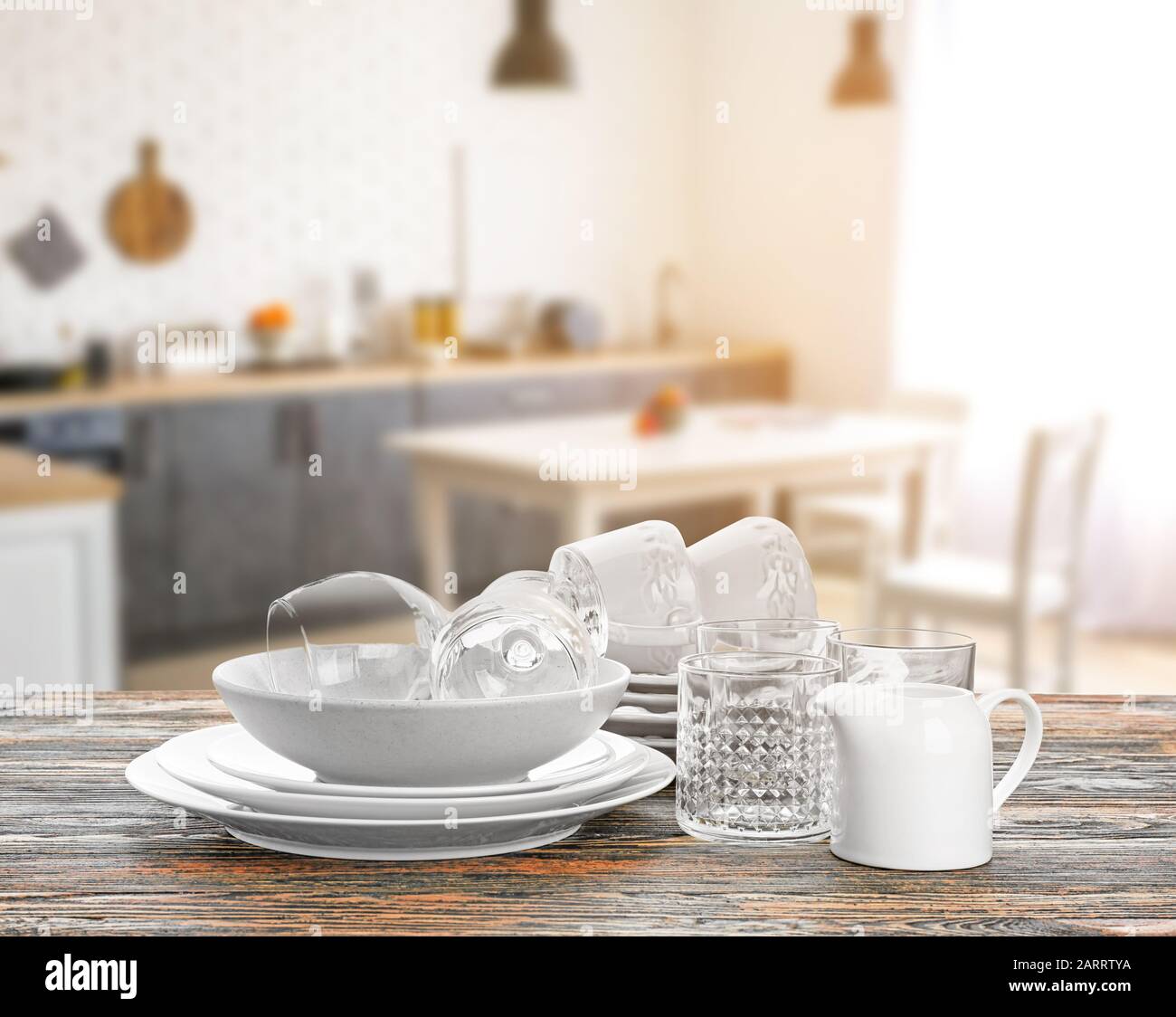 Set of clean dishes on wooden table in modern kitchen Stock Photo - Alamy