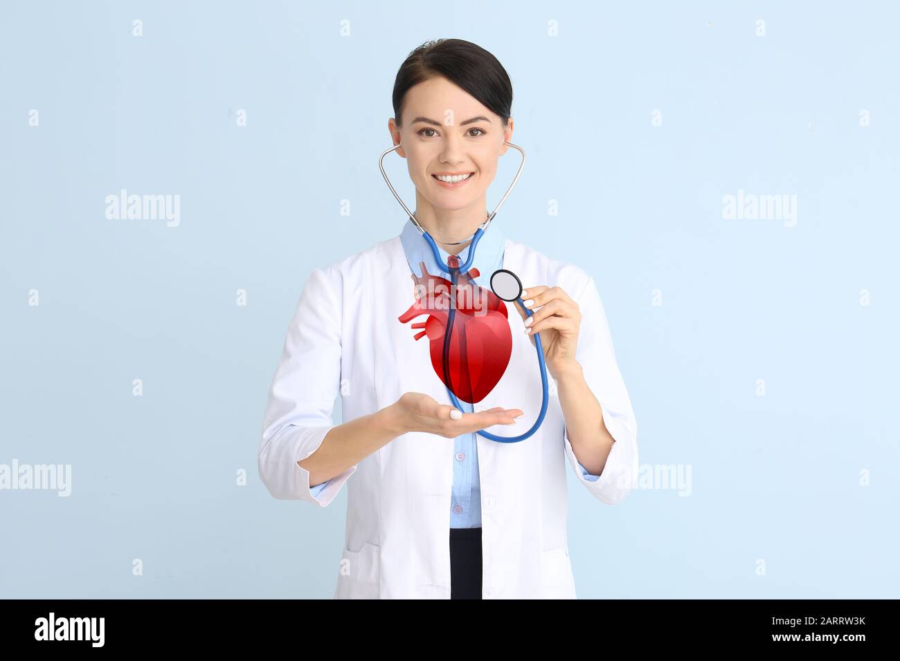 Female cardiologist with drawn heart and stethoscope on color ...