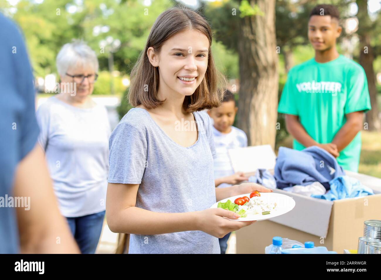 Poor teenager girl with received food from volunteers Stock Photo - Alamy