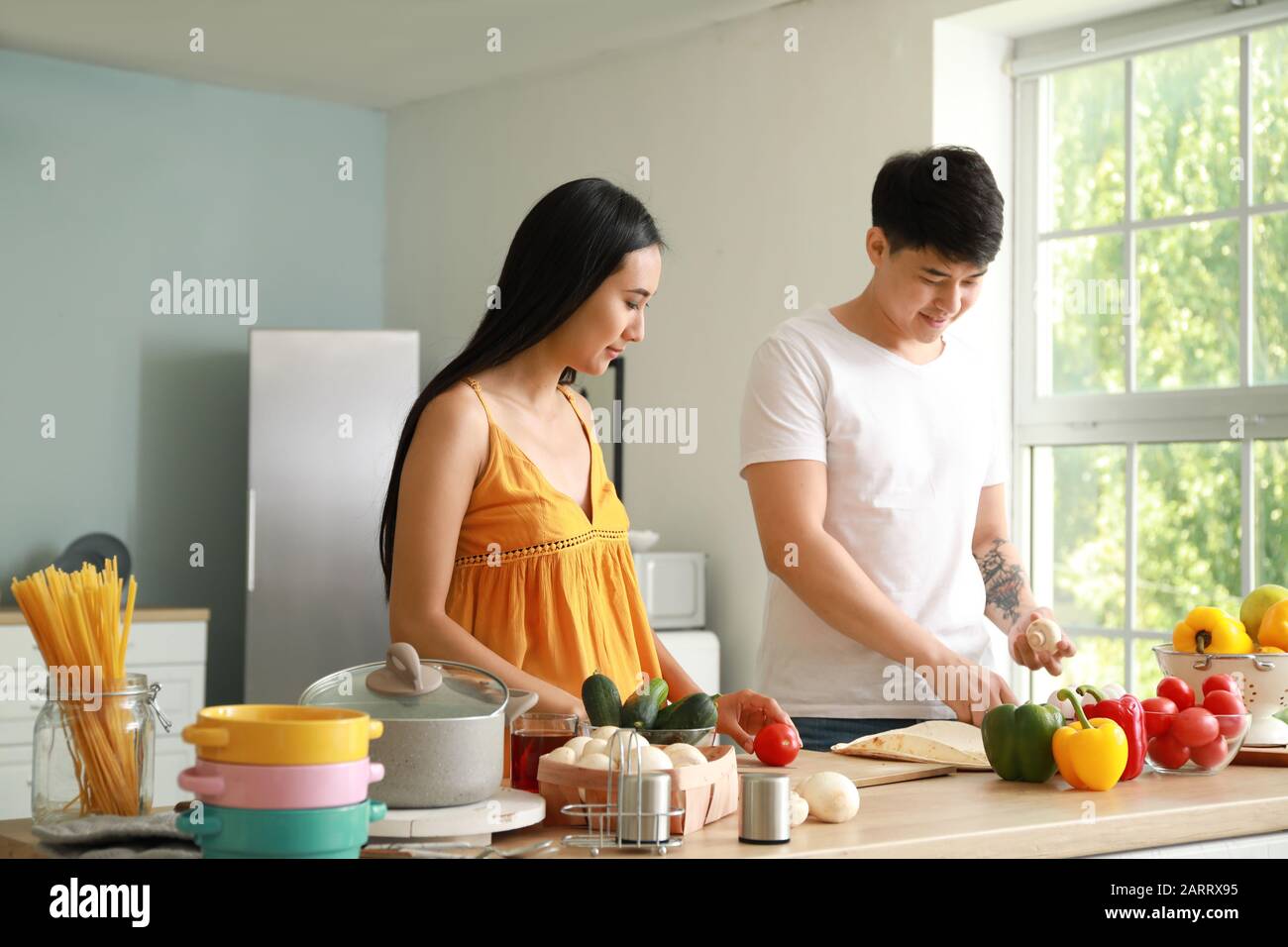 Happy Asian couple cooking together in kitchen Stock Photo - Alamy