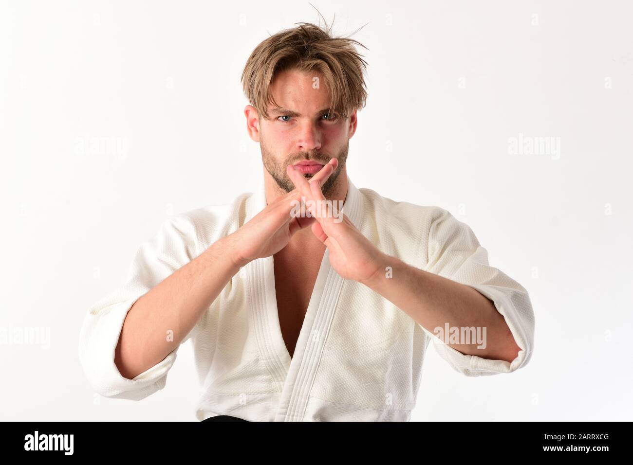 Guy poses in white kimono. Man with serious face and bristle isolated ...