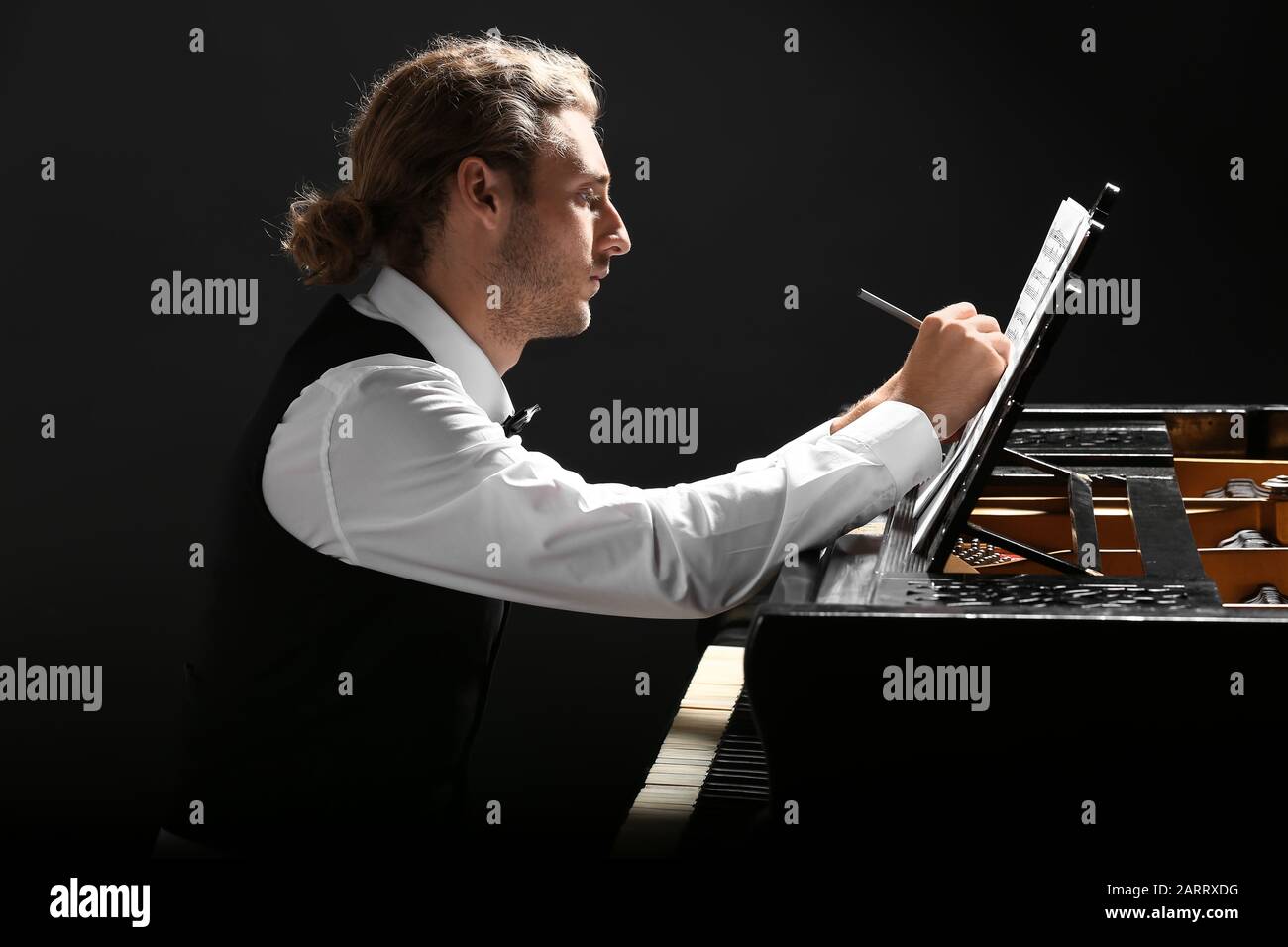 Composer at grand piano on dark background Stock Photo - Alamy