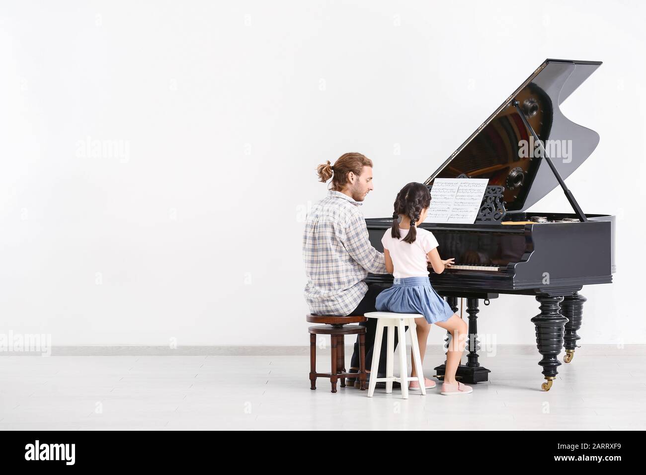 Man teaching girl play piano hi-res stock photography and images - Alamy