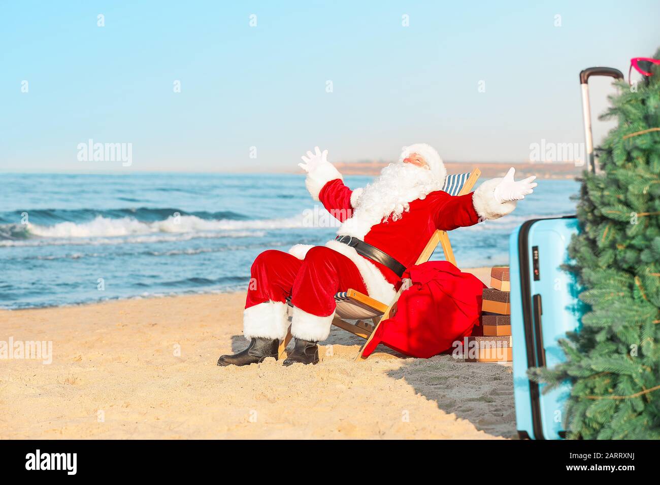 Happy Santa Claus with gifts resting at sea resort Stock Photo - Alamy