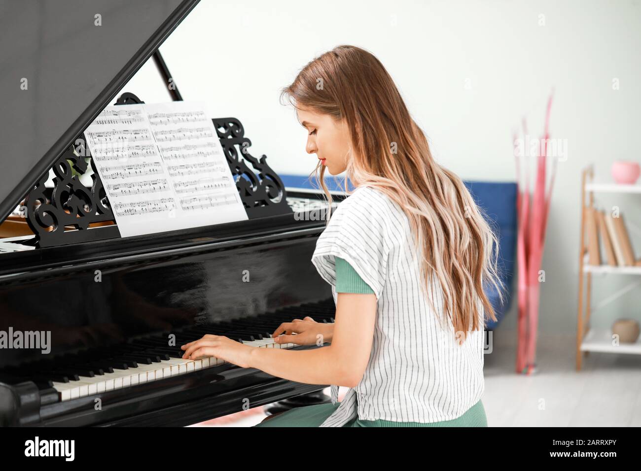 Young woman playing grand piano hi-res stock photography and images - Alamy