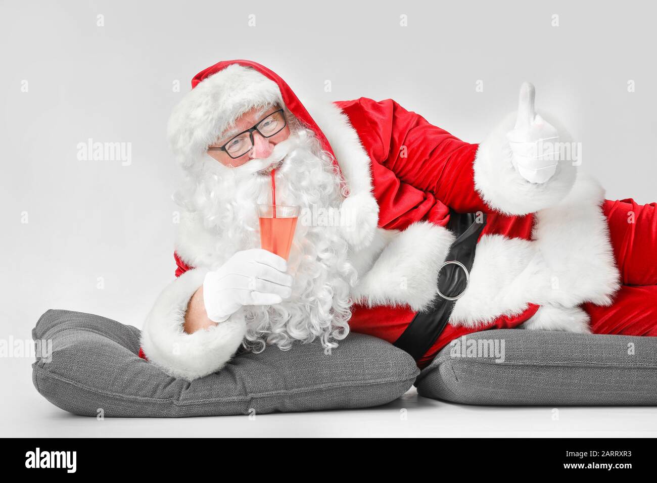 Lying Santa Claus with cocktail showing OK gesture on white background ...