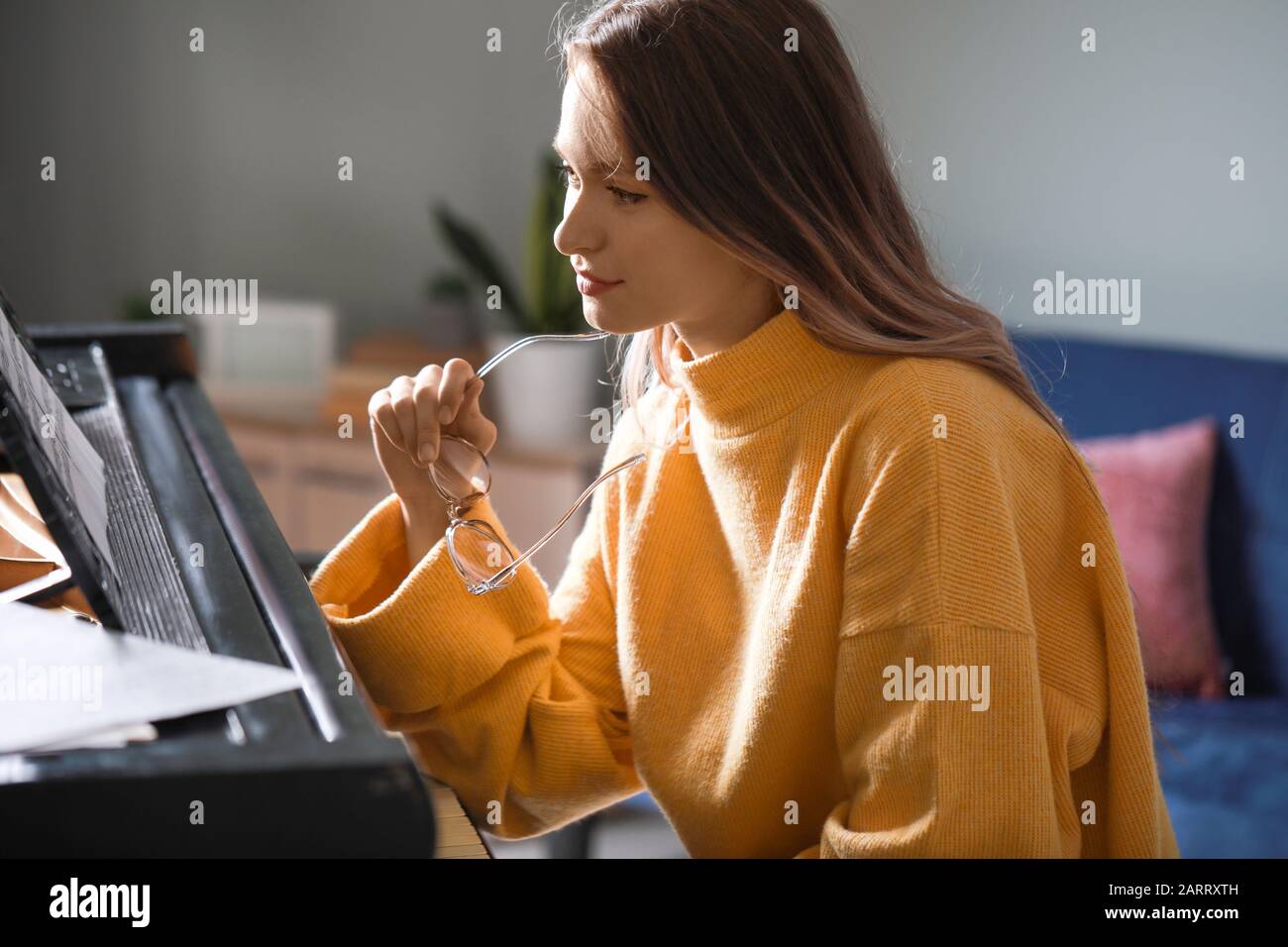 Female composer waiting for inspiration while sitting at grand piano ...