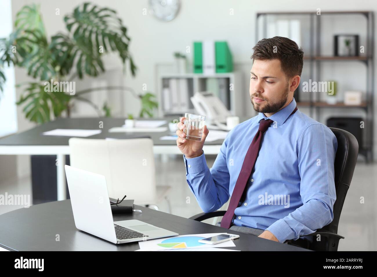 Portrait of businessman drinking water in office Stock Photo - Alamy
