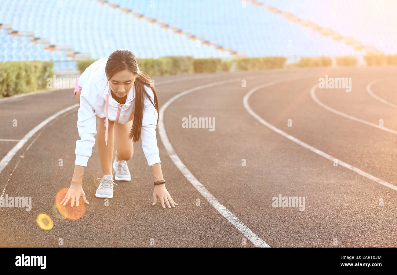 Sporty Asian woman in crouch start position at the stadium Stock Photo ...
