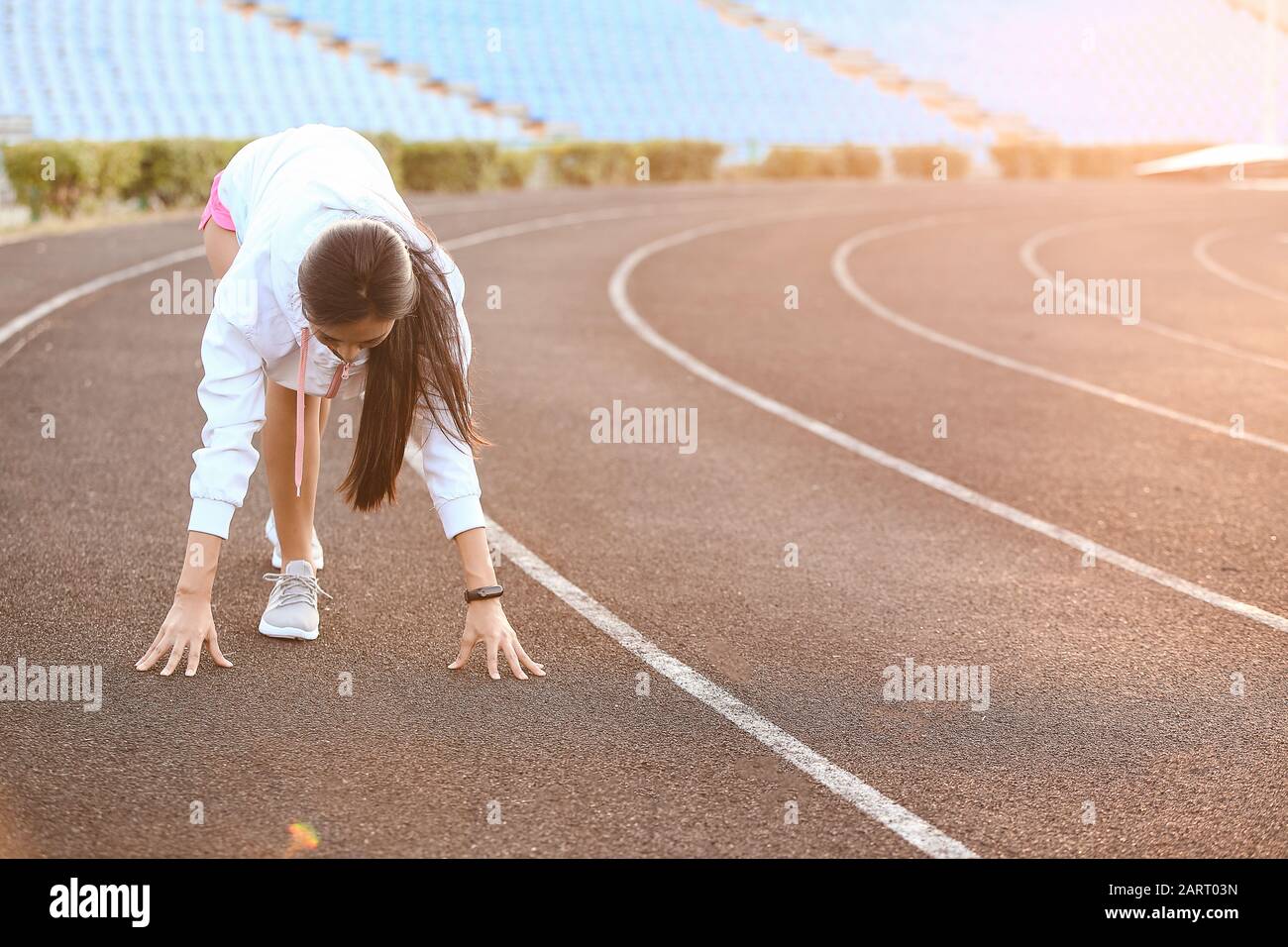 Sporty Asian woman in crouch start position at the stadium Stock Photo ...