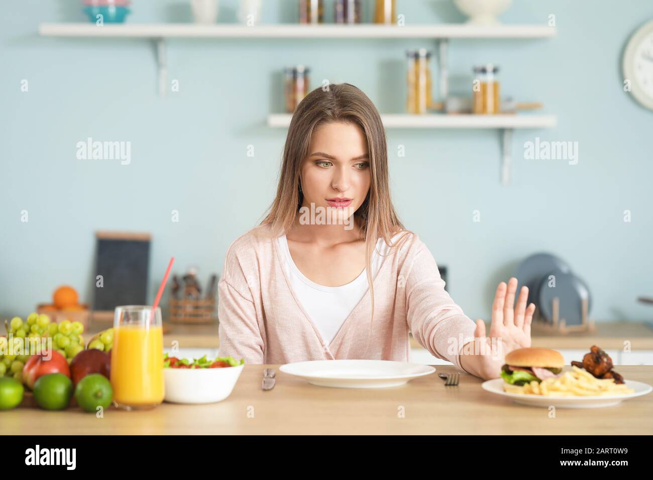 Woman refusing to eat unhealthy food in kitchen. Diet concept Stock ...