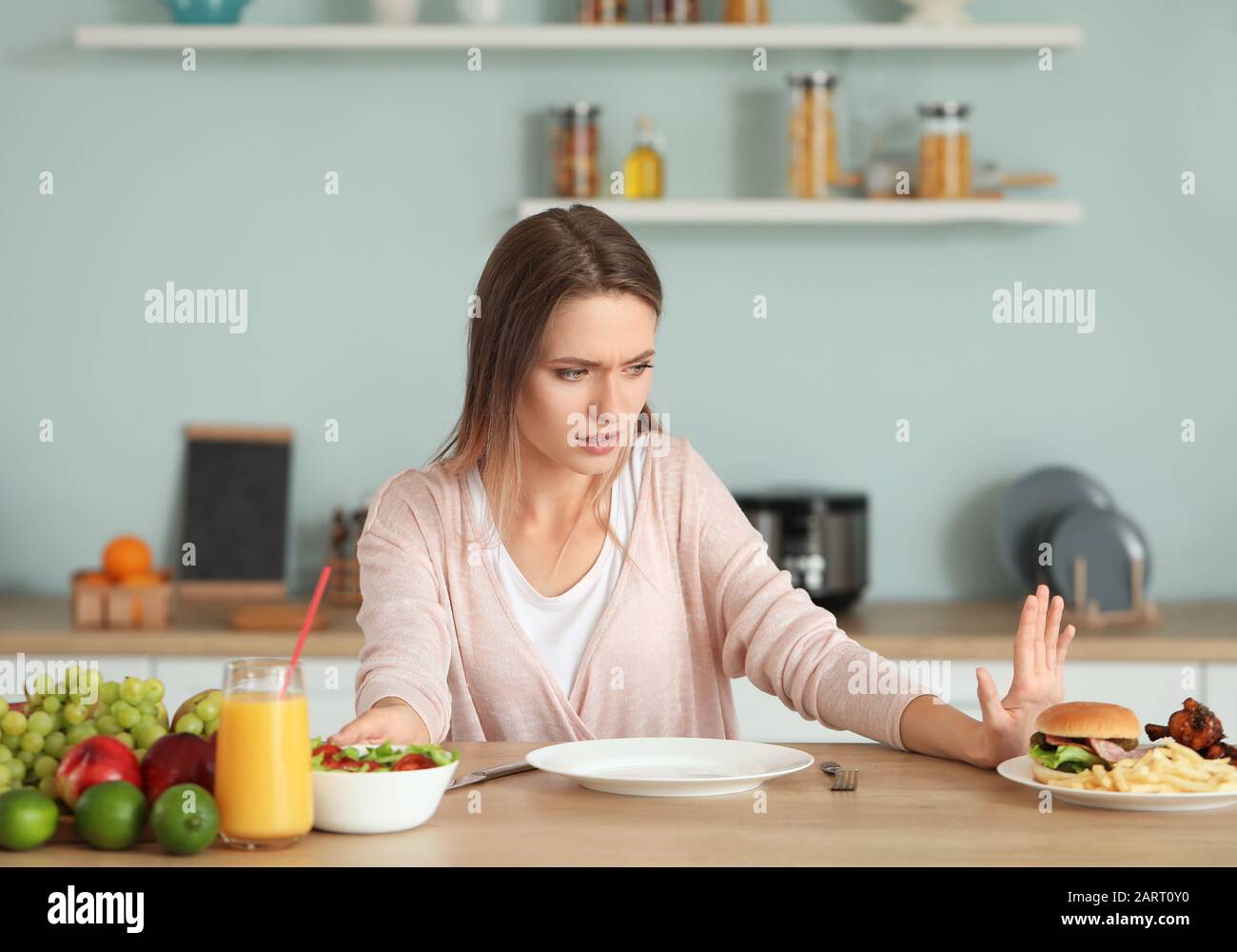 Woman refusing to eat unhealthy food in kitchen. Diet concept Stock ...