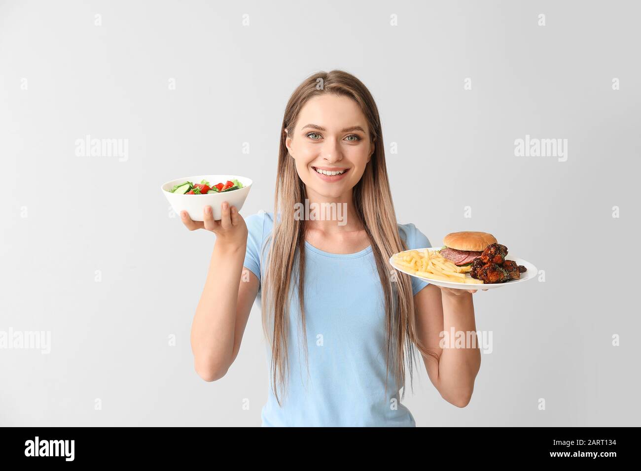 Woman with healthy and unhealthy food on light background. Diet concept ...