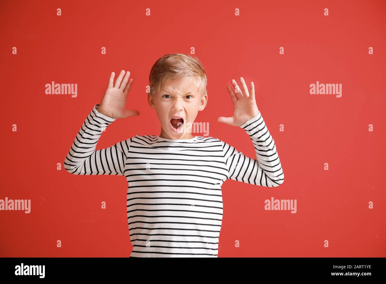 Portrait of angry little boy on color background Stock Photo - Alamy
