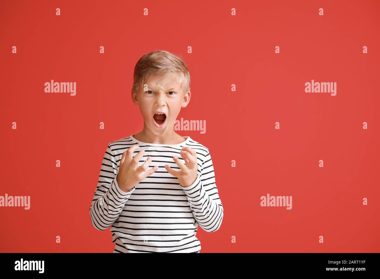 Portrait of angry little boy on color background Stock Photo - Alamy