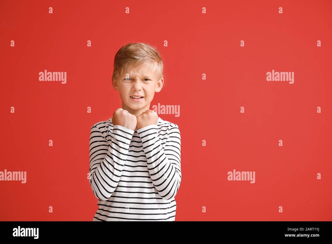 Portrait of angry little boy on color background Stock Photo - Alamy