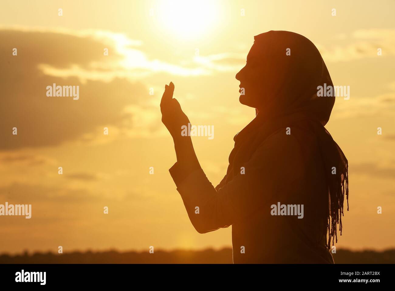 Beautiful Muslim woman praying outdoors at sunset Stock Photo - Alamy