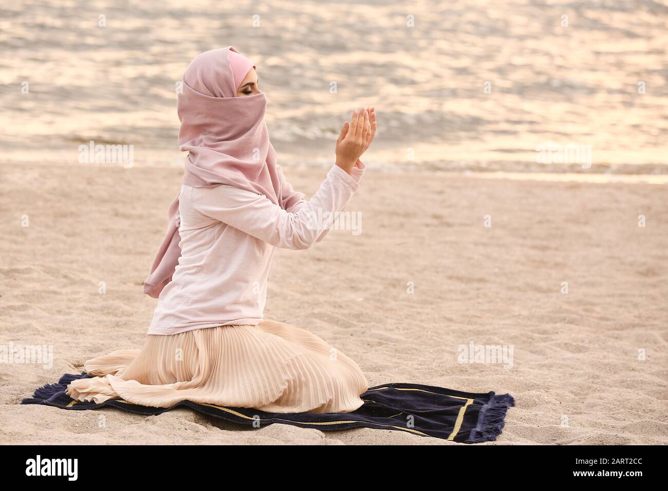 Beautiful Muslim woman praying near river Stock Photo - Alamy