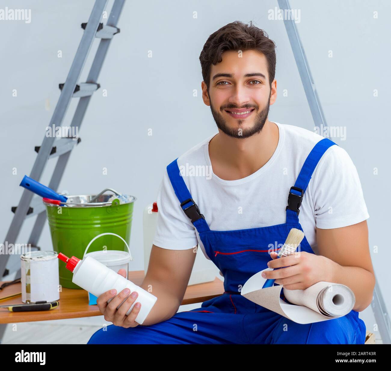 Repairman doing renovation repair in the house with paper wallpaper ...